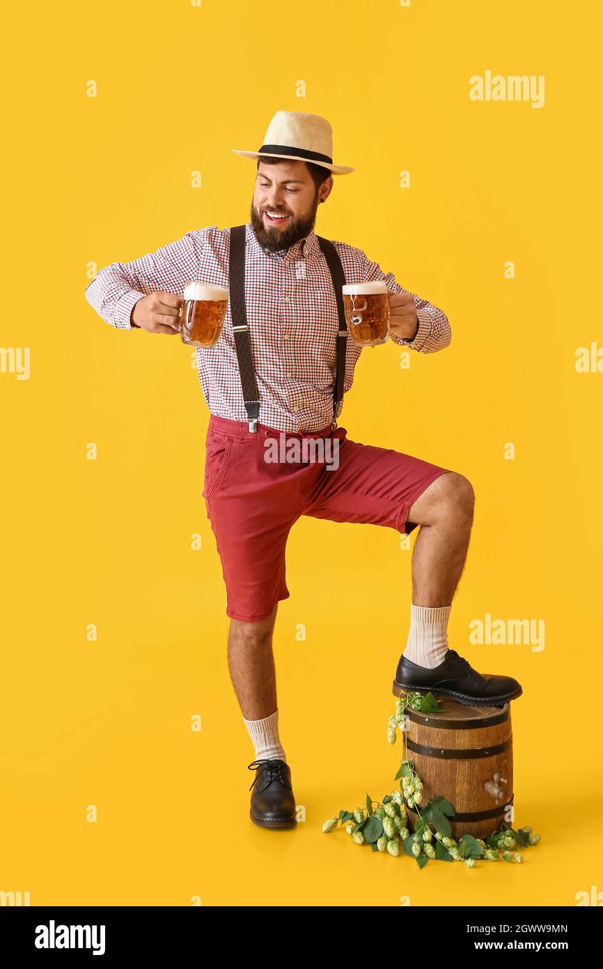 Handsome man in traditional German clothes and with beer on color ...
