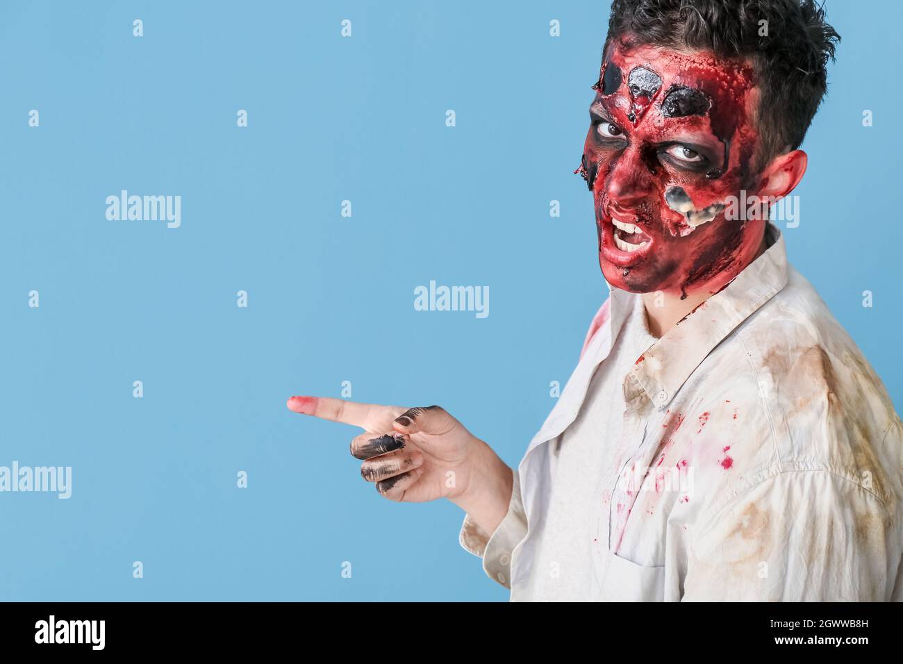 Scary zombie man on color background Stock Photo - Alamy