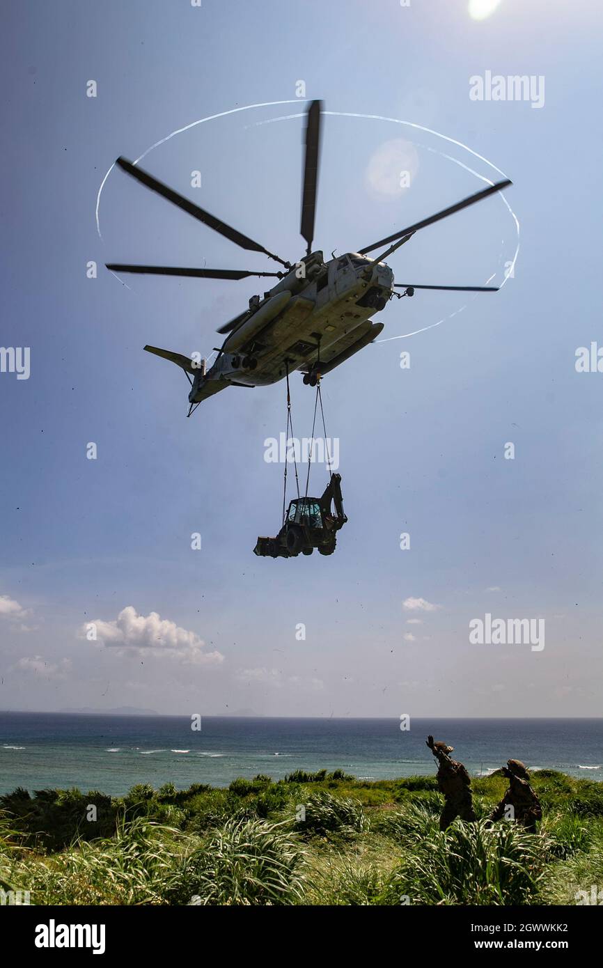 A CH-53E Super Stallion heavy-lift helicopter relocates a backhoe from ...