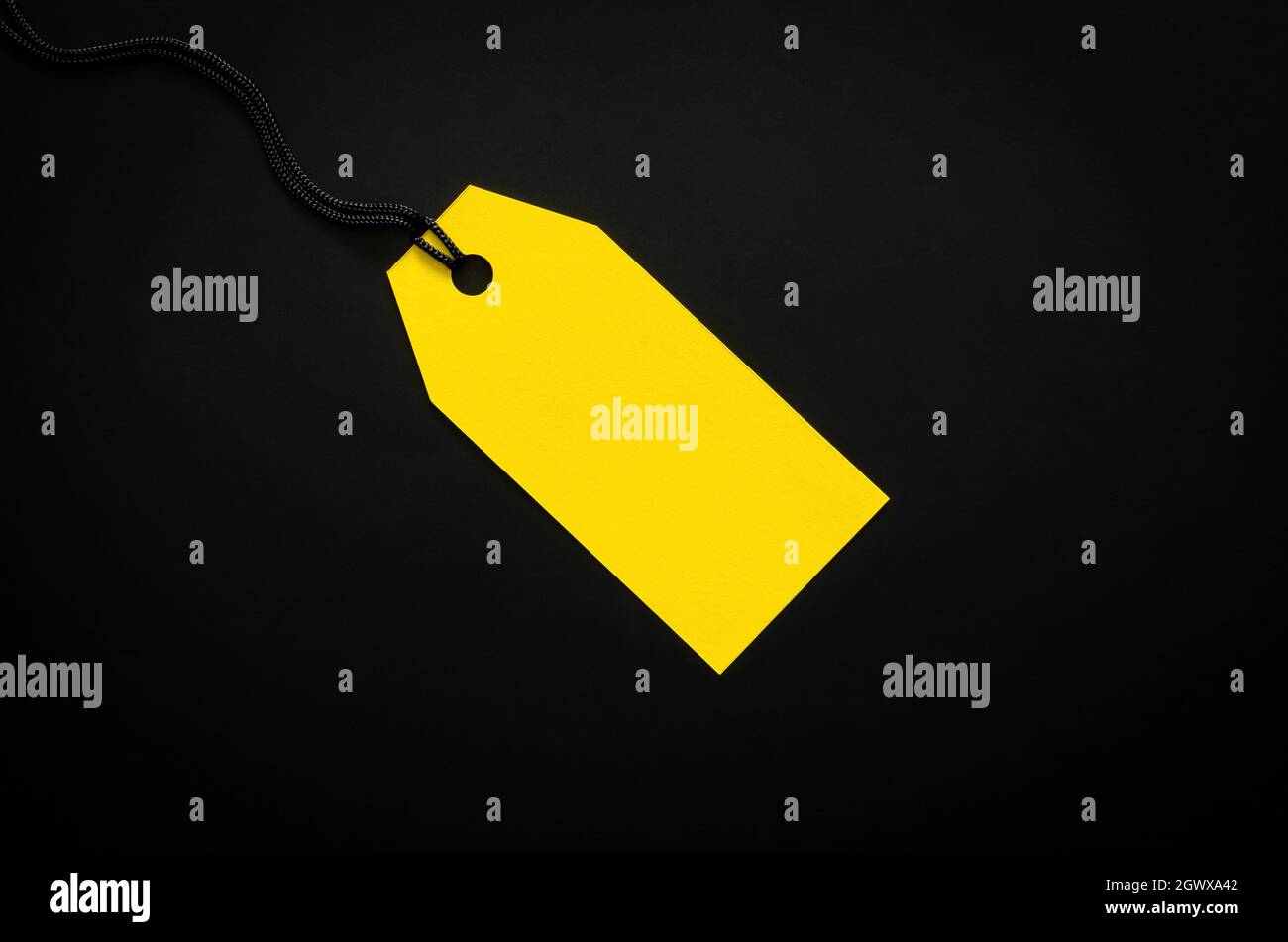 A yellow blank price tag on black background for shopping and discount ...