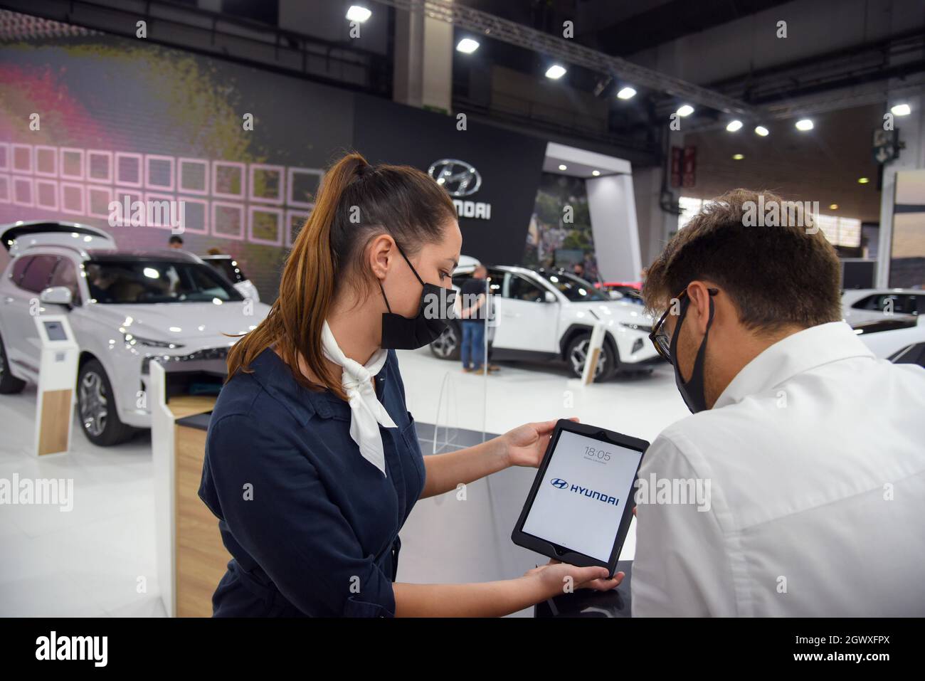 An information hostess of the Hyundai brand attends to a visitor at the ...