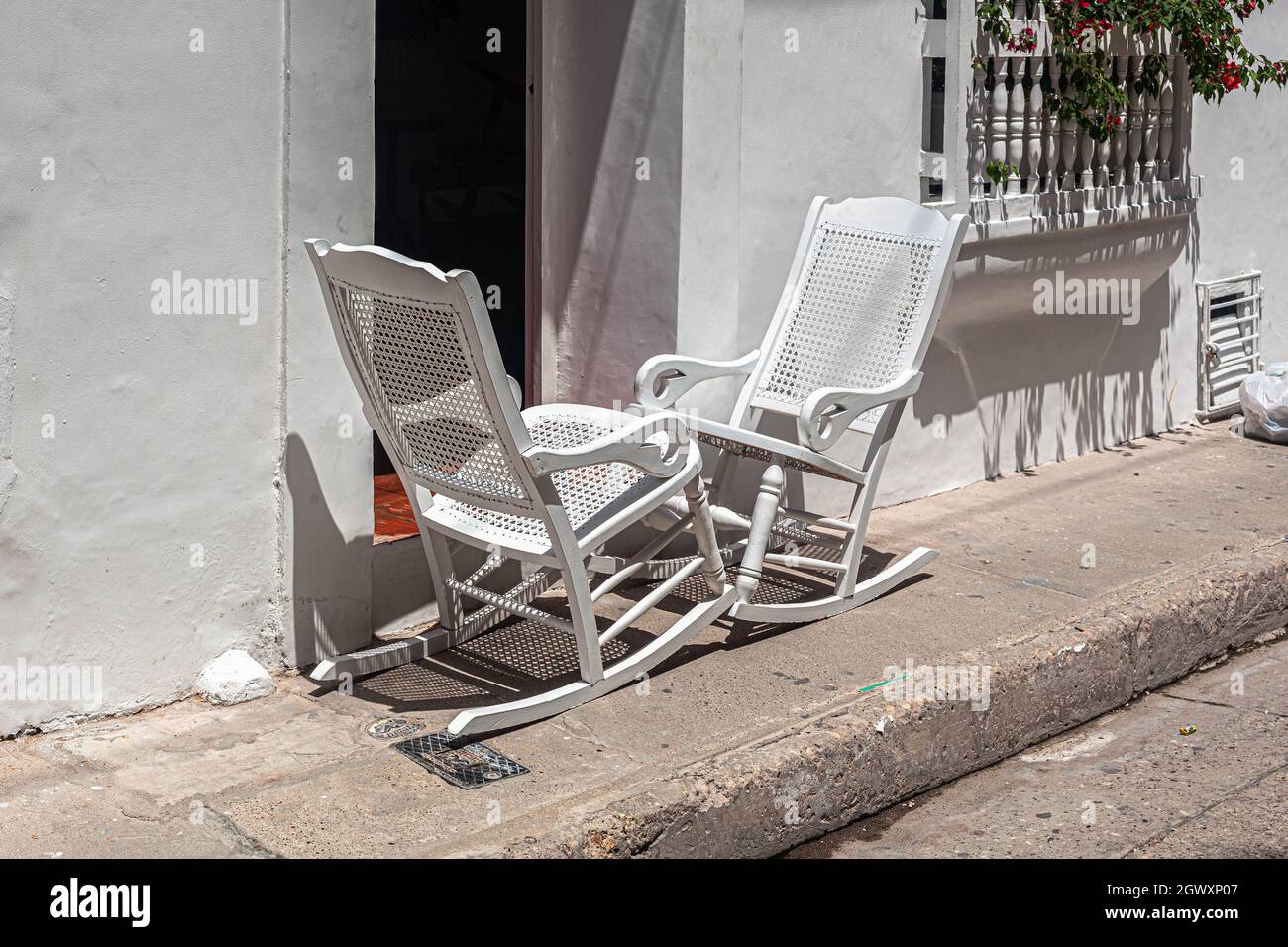 Two wooden rocking chairs on a pavement, just outside a Republican ...