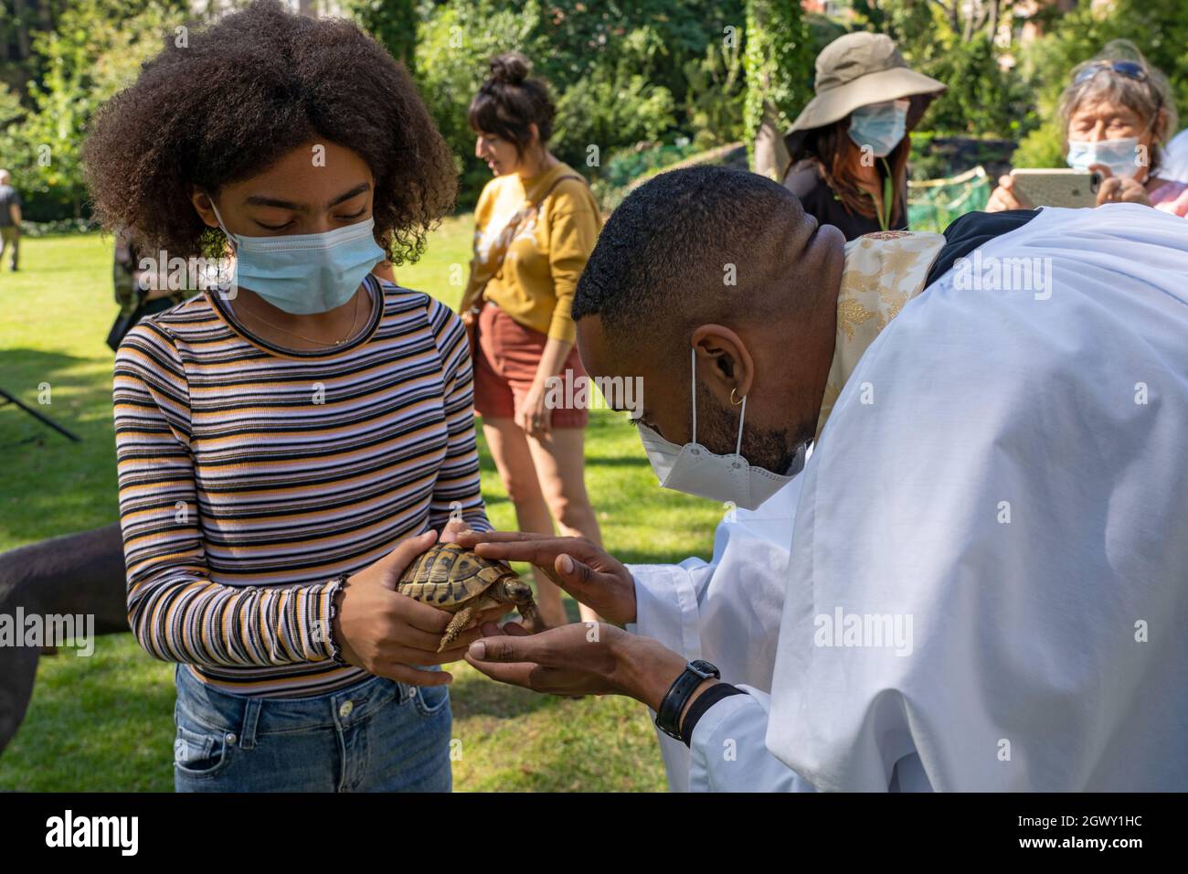A priest blesses a turtle during the Blessing of the Animals at the ...
