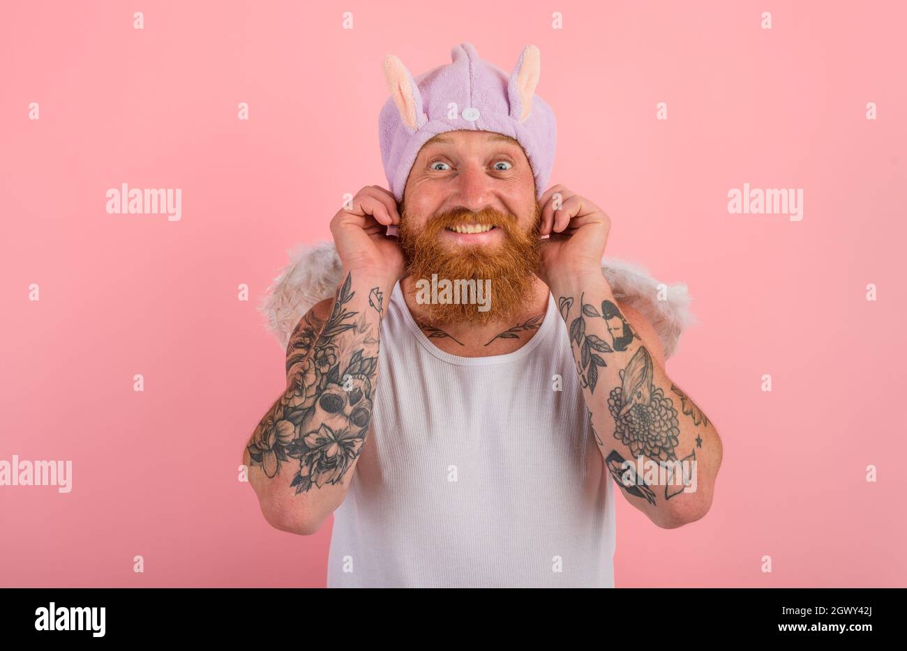 Happy man with beard and tattoos acts like an angel Stock Photo - Alamy