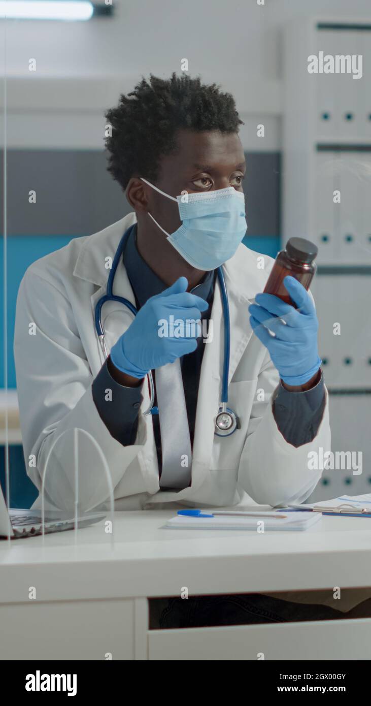 Young medic showing bottle of pills to elder patient for healing ...