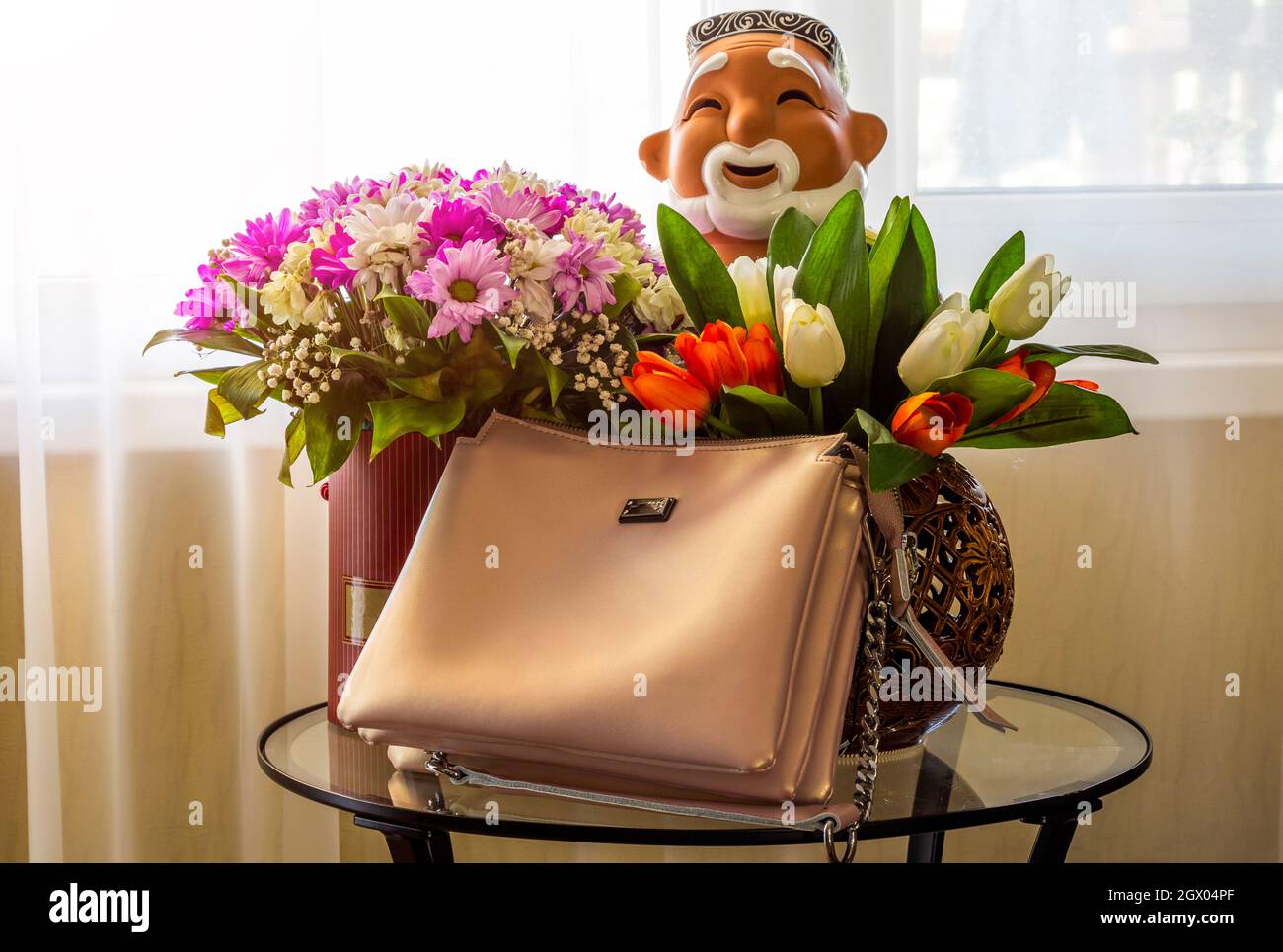Various objects and flowers on a round glass table Stock Photo - Alamy