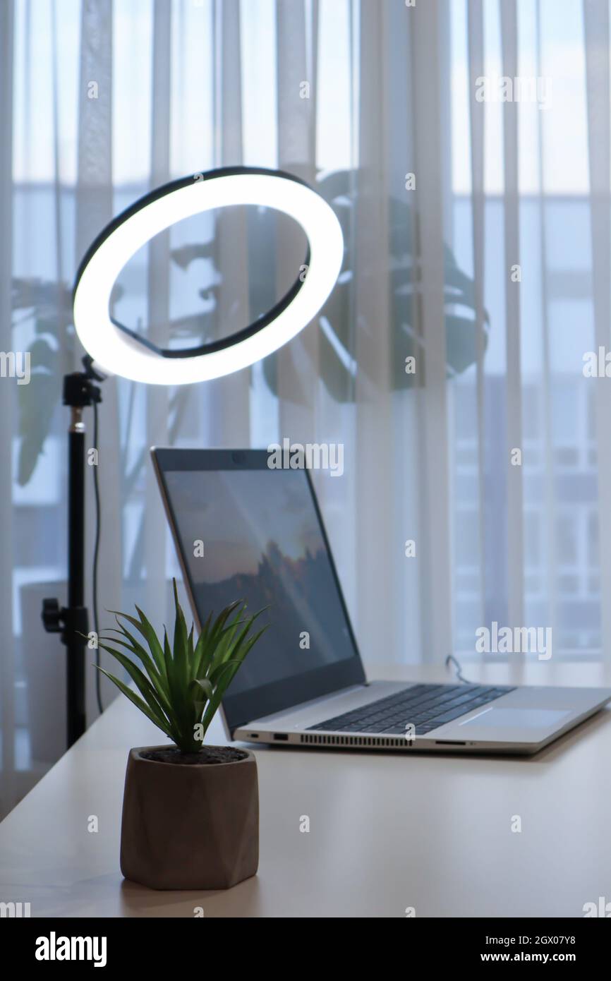 Working place at home with a laptop and a ring lamp. Minimalism ...