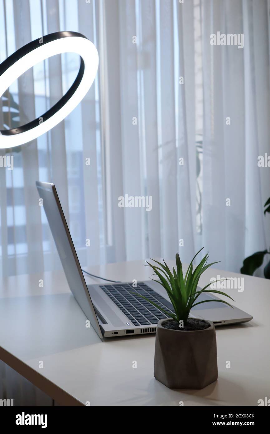 Working place at home with a laptop and a ring lamp. Minimalism ...