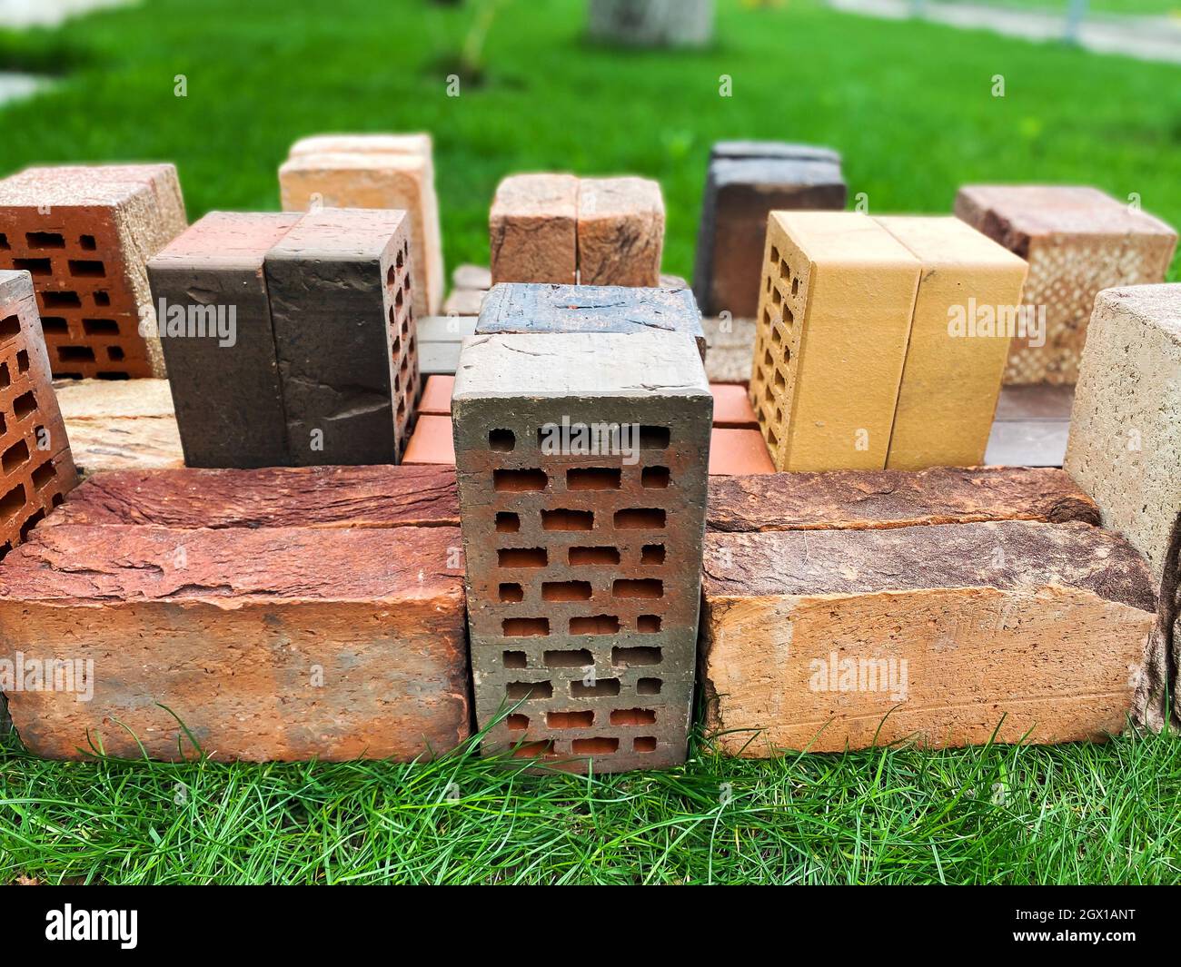 Different types of bricks stacked beautifully on green grass Stock ...