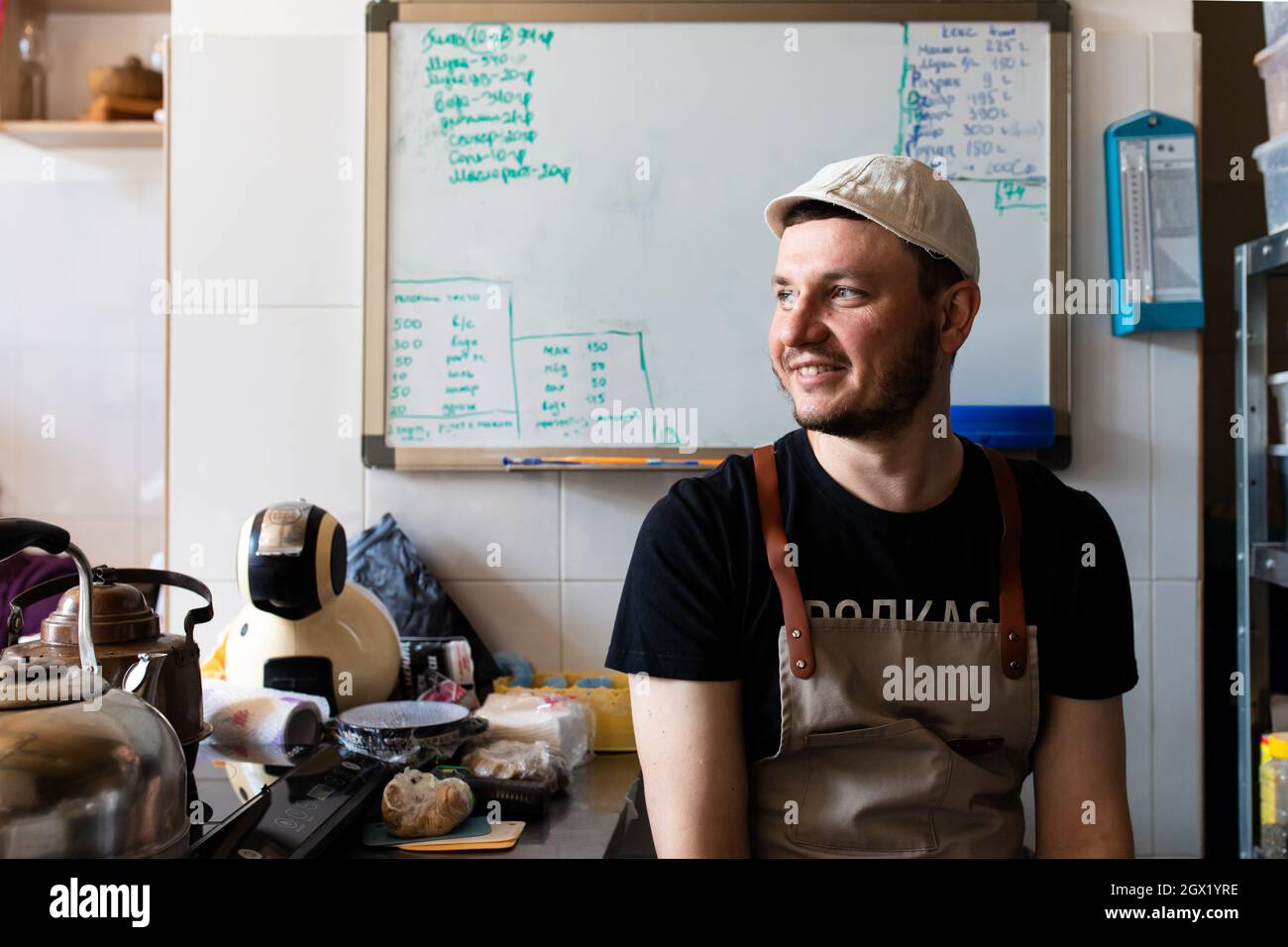 A young man in a cap and apron at the baker's job Stock Photo - Alamy