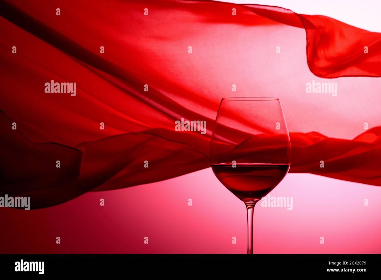 Glass of red wine on a background of waving red satin curtain Stock ...