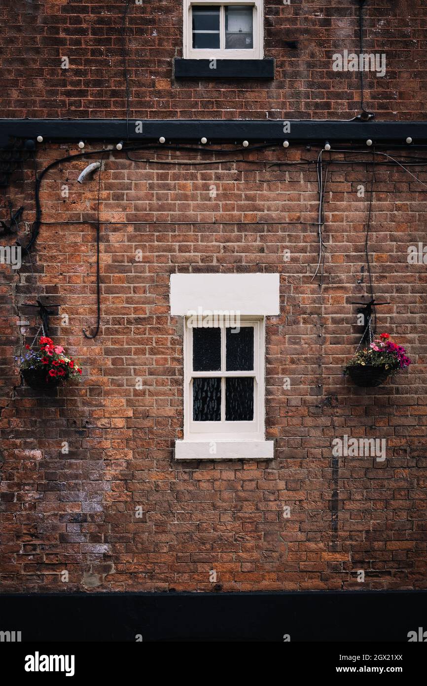 Vertical shot of a white window on an old brick wall of a house ...