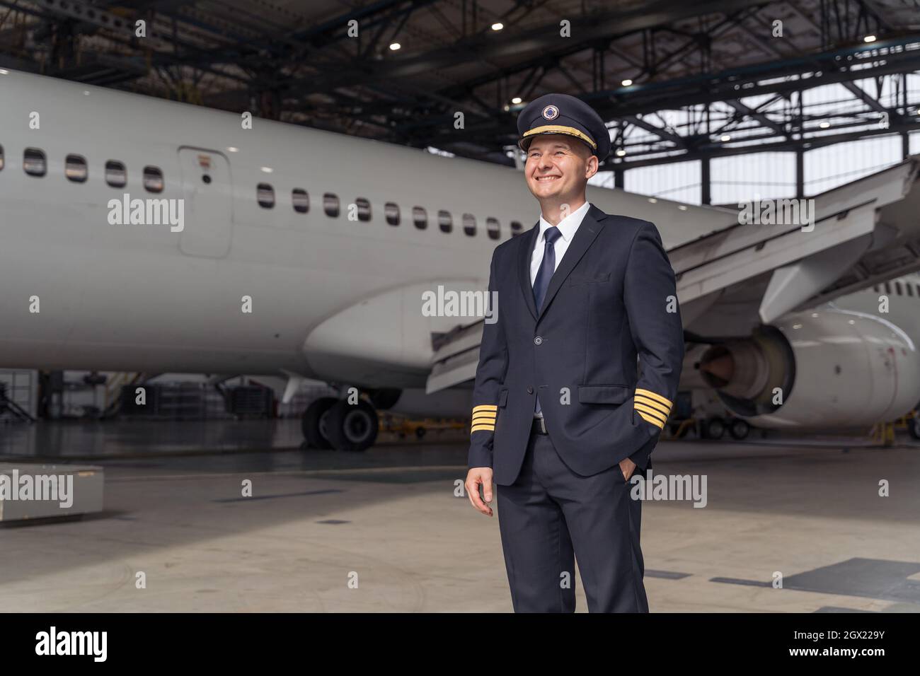 Handsome pilot posing against the backdrop of the aircraft in the ...