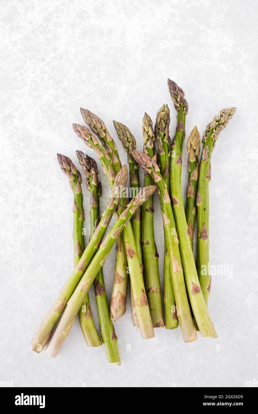 Top view of raw and fresh green asparagus stems on gray pattern ...