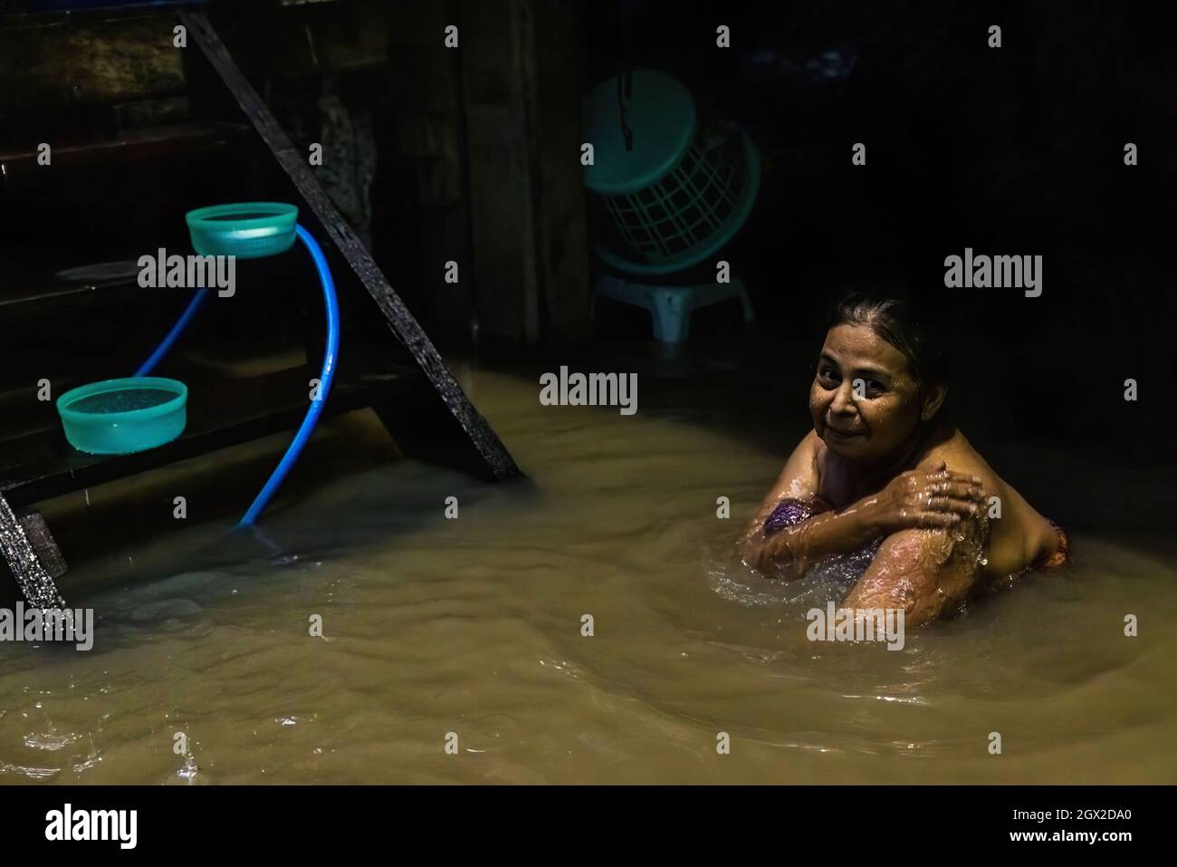 Nonthaburi, Thailand. 03rd Oct, 2021. A woman is seen taking a bath in ...