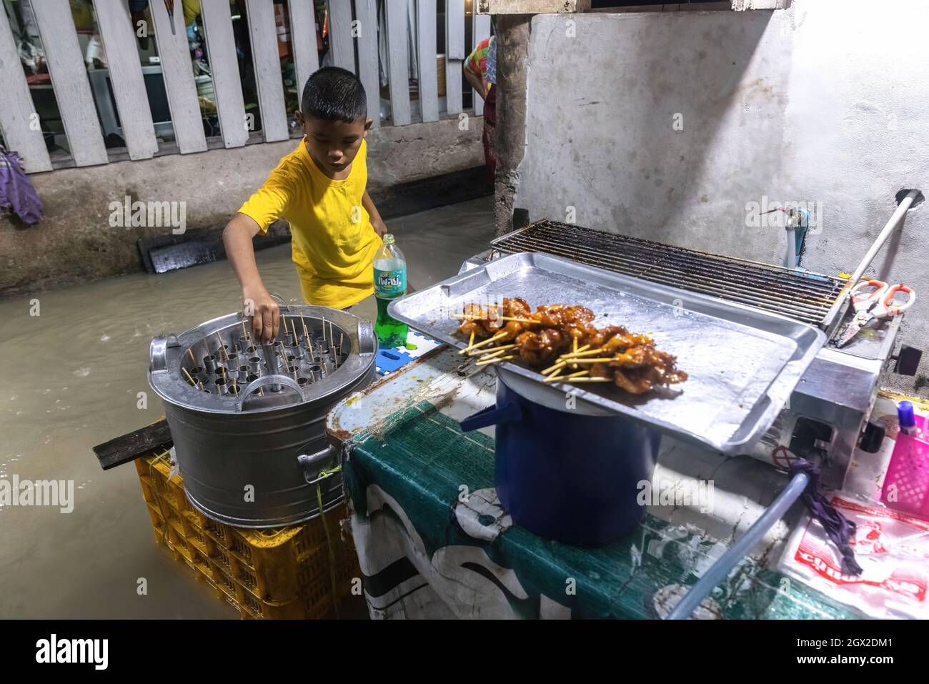A boy is seen making ice cream in a flooded area. Thailand has faced ...