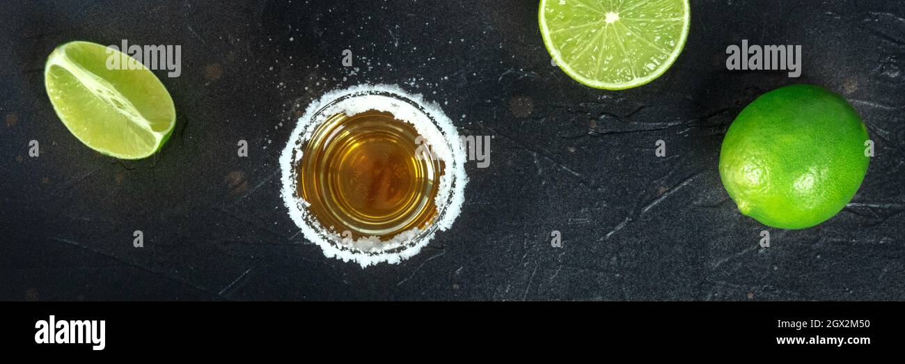 Tequila gold shot with lime slices panorama, a Mexican drink with a ...