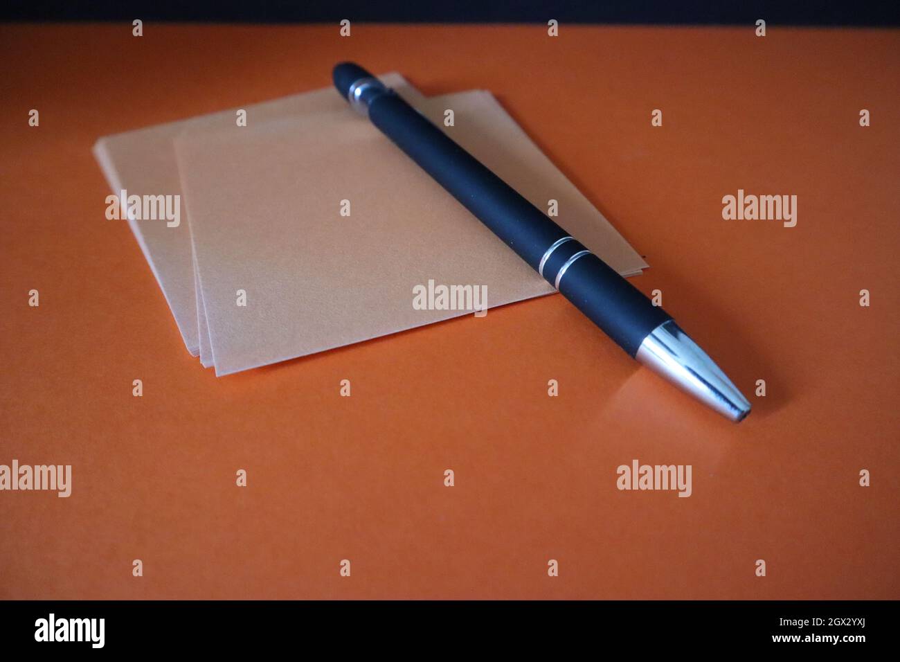 Closeup shot of a pen and blank stickers isolated on a brown background ...