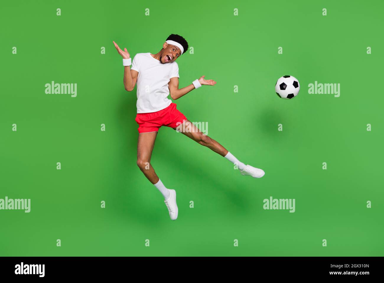 Photo of funky active guy jump kick ball wear headband white t-shirt ...