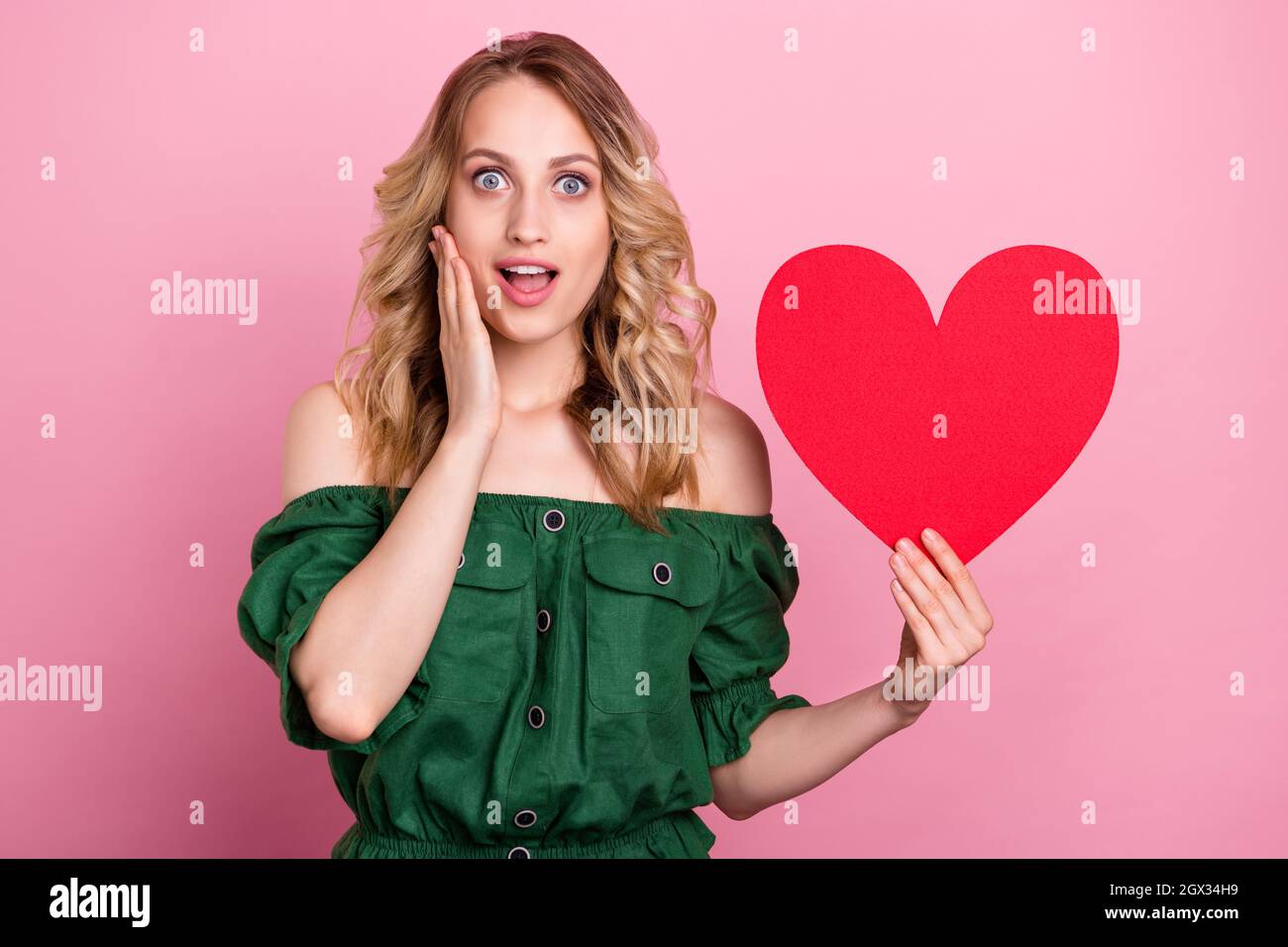 Photo of excited lover lady hold red heart palm cheek wear bear ...