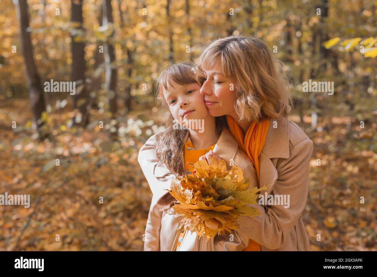 Young mother with her little daughter in an autumn park. Fall season ...