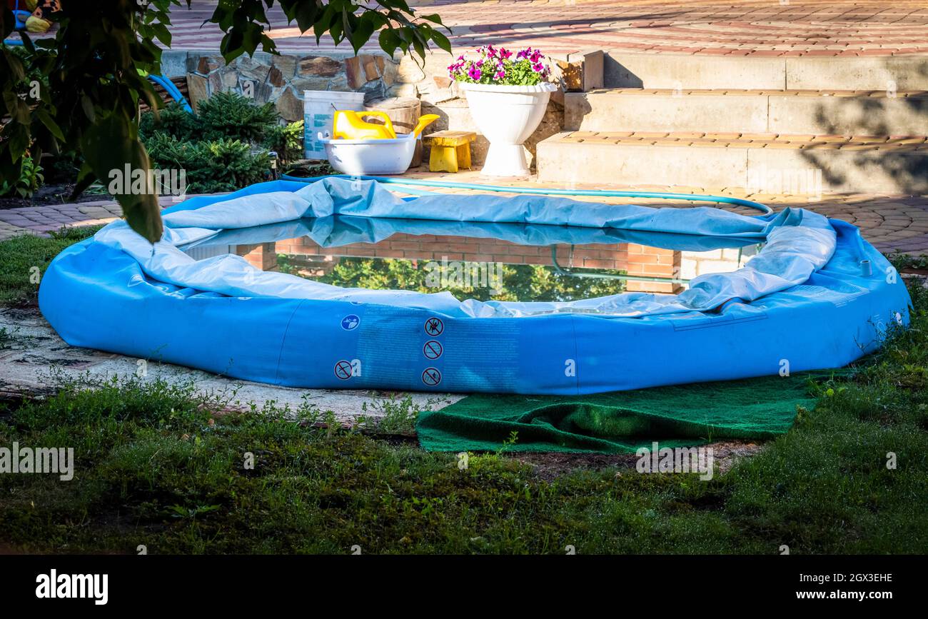 A deflated inflatable pool on the backyard lawn Stock Photo - Alamy