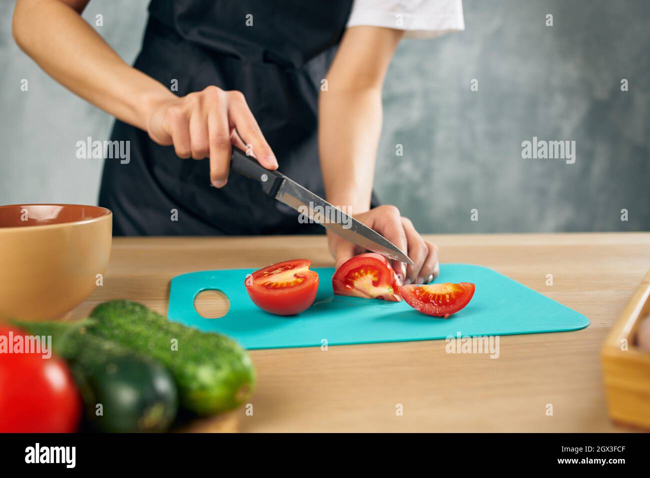 Cook woman on the kitchen cutting vegetables isolated background Stock ...