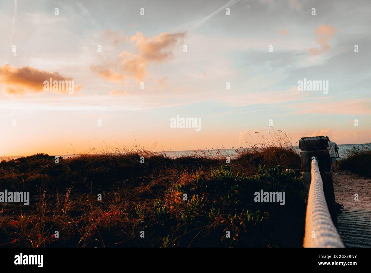 Scenic view of railings of a bridge near a shore during sunset Stock ...