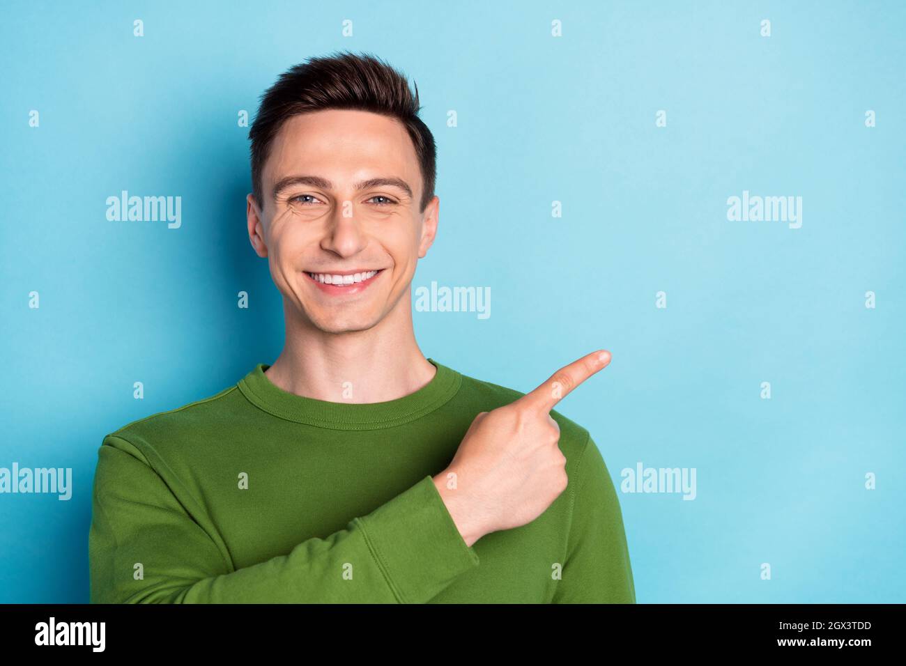 Photo of reliable man direct finger empty space promote sale wear green ...