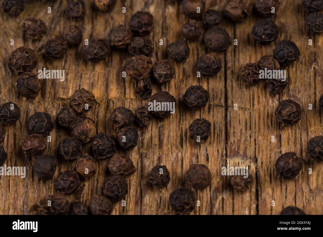 black pepper on a wood background table Stock Photo - Alamy