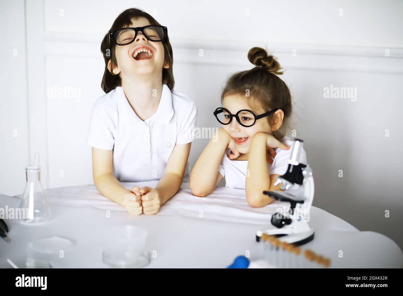 Two cute children at chemistry lesson making experiments isolated on ...