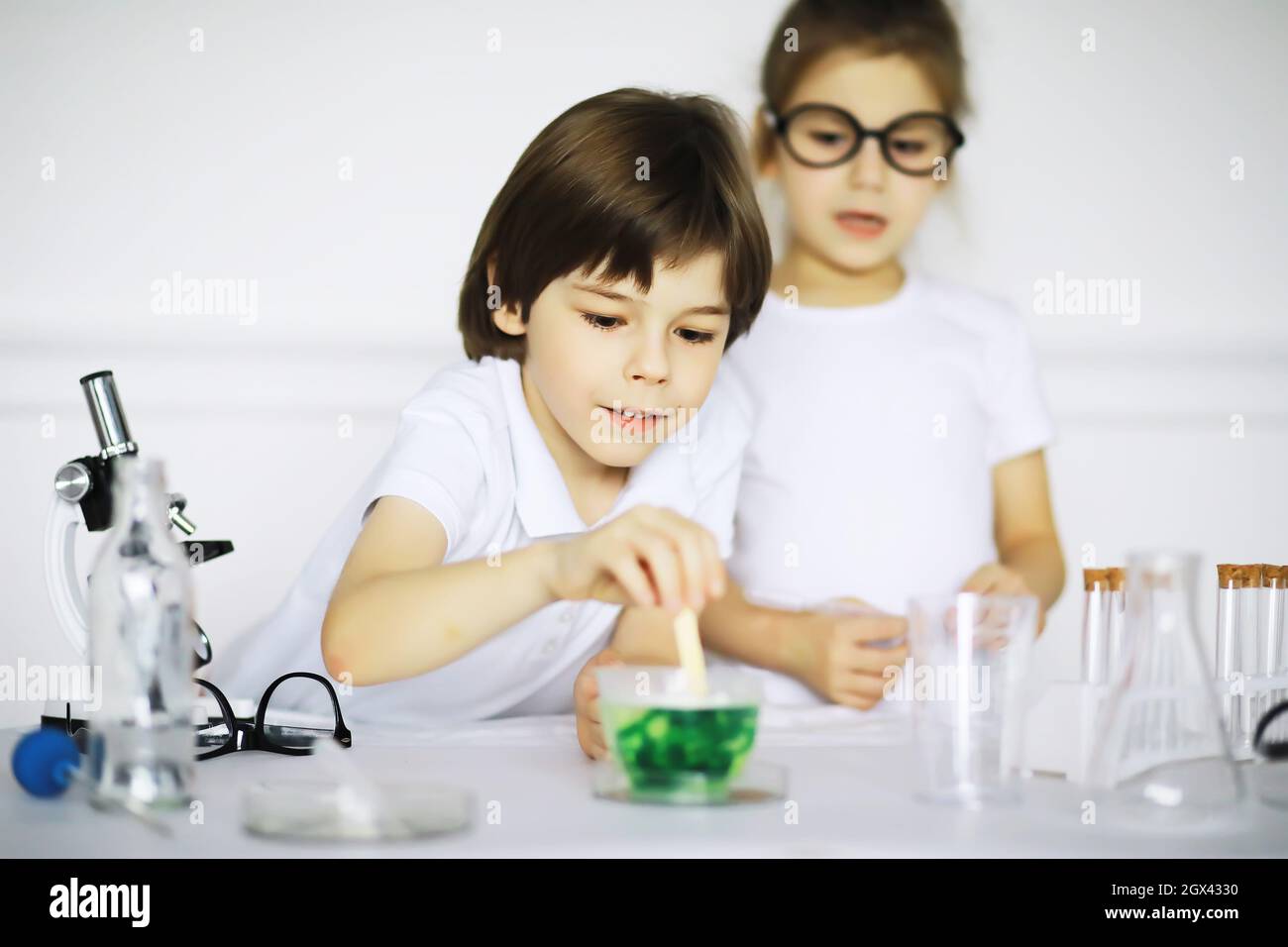 Two cute children at chemistry lesson making experiments isolated on ...