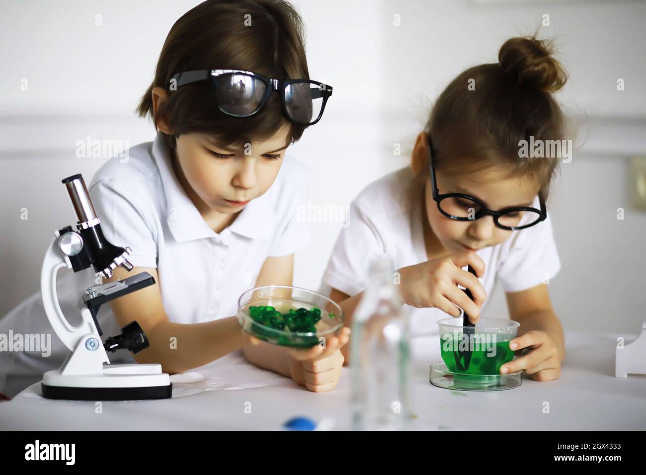Two cute children at chemistry lesson making experiments isolated on ...