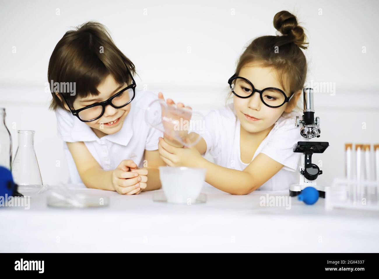 Two cute children at chemistry lesson making experiments isolated on ...