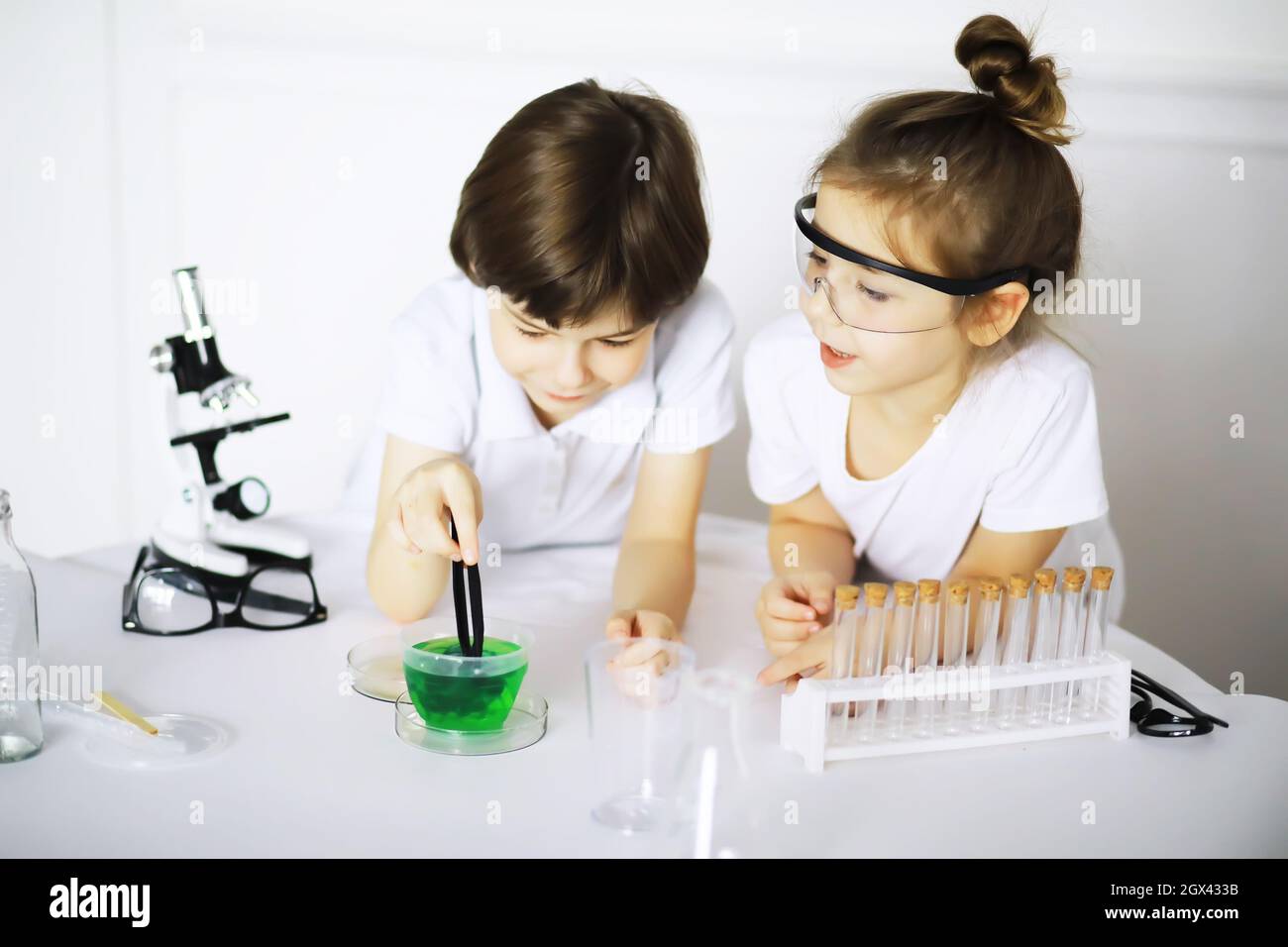 Two cute children at chemistry lesson making experiments isolated on ...