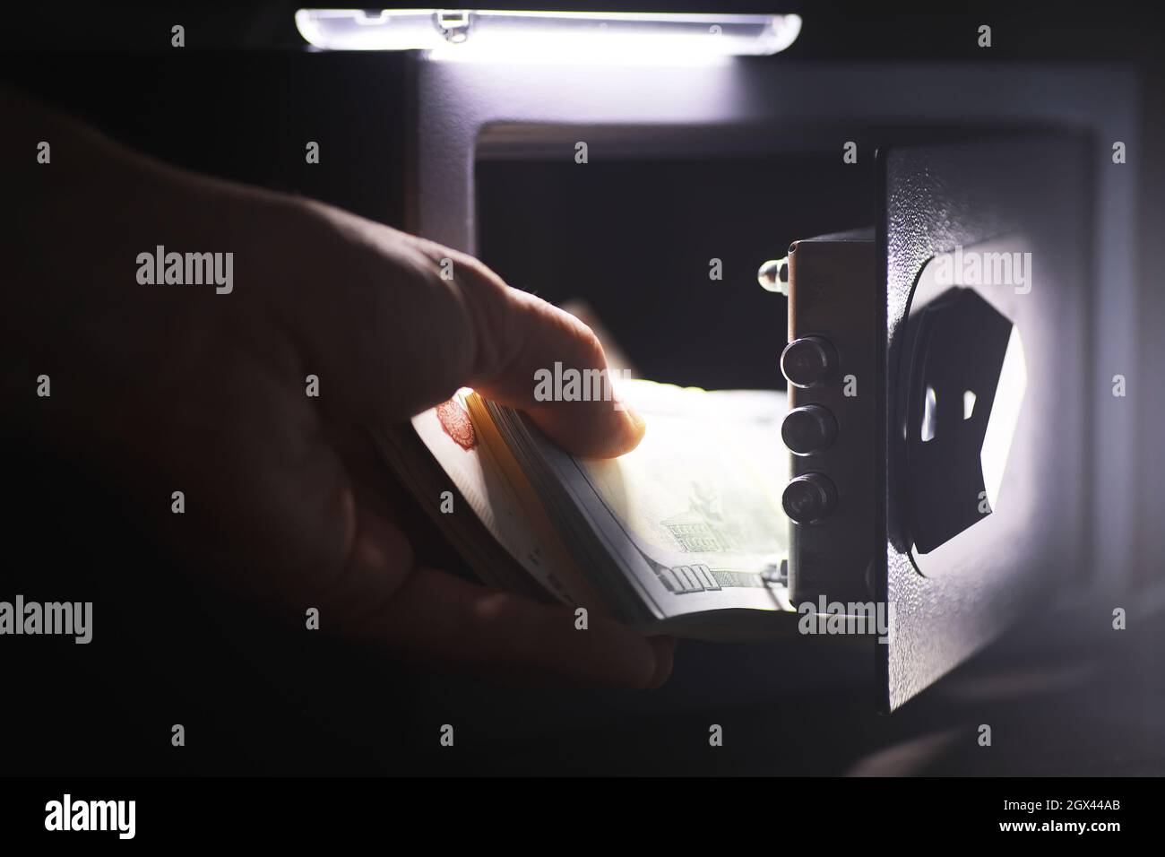 Steel safe with money. Hand putting password in the safety money box in ...