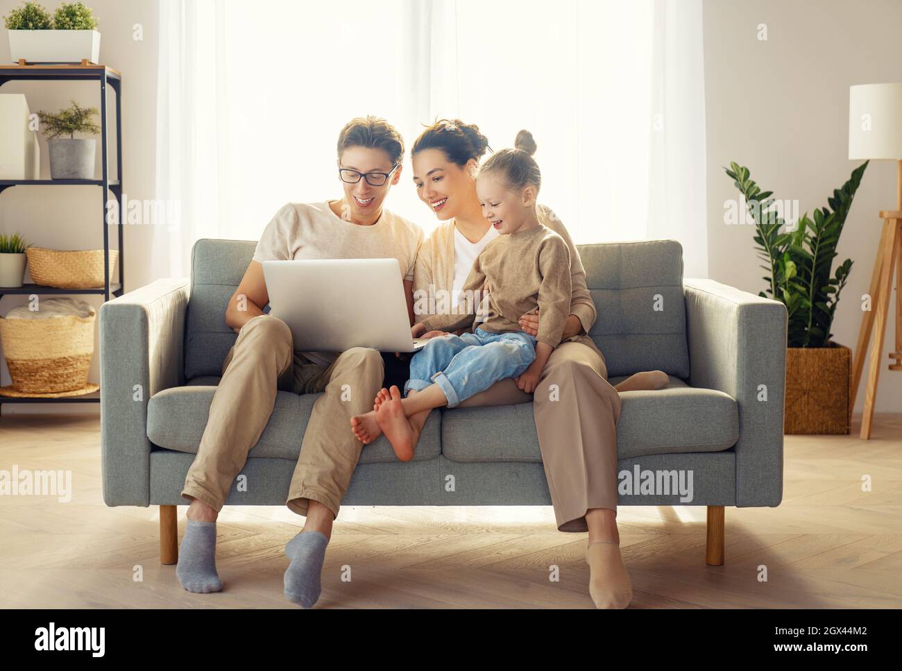 Happy loving family. Young mother, father and daughter using laptop ...