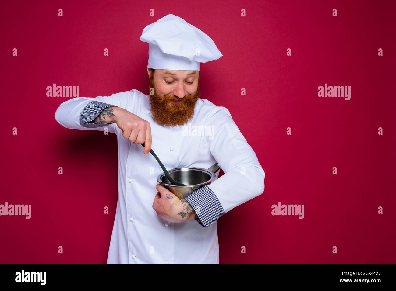 Happy chef with beard and red apron is ready to cook Stock Photo - Alamy