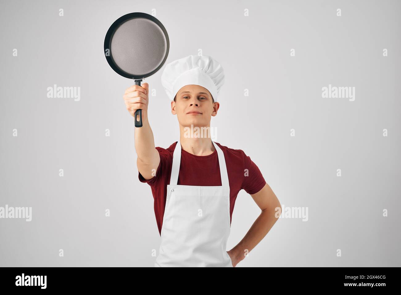 man chef with a cap on his head Frying pan in his hand light background ...