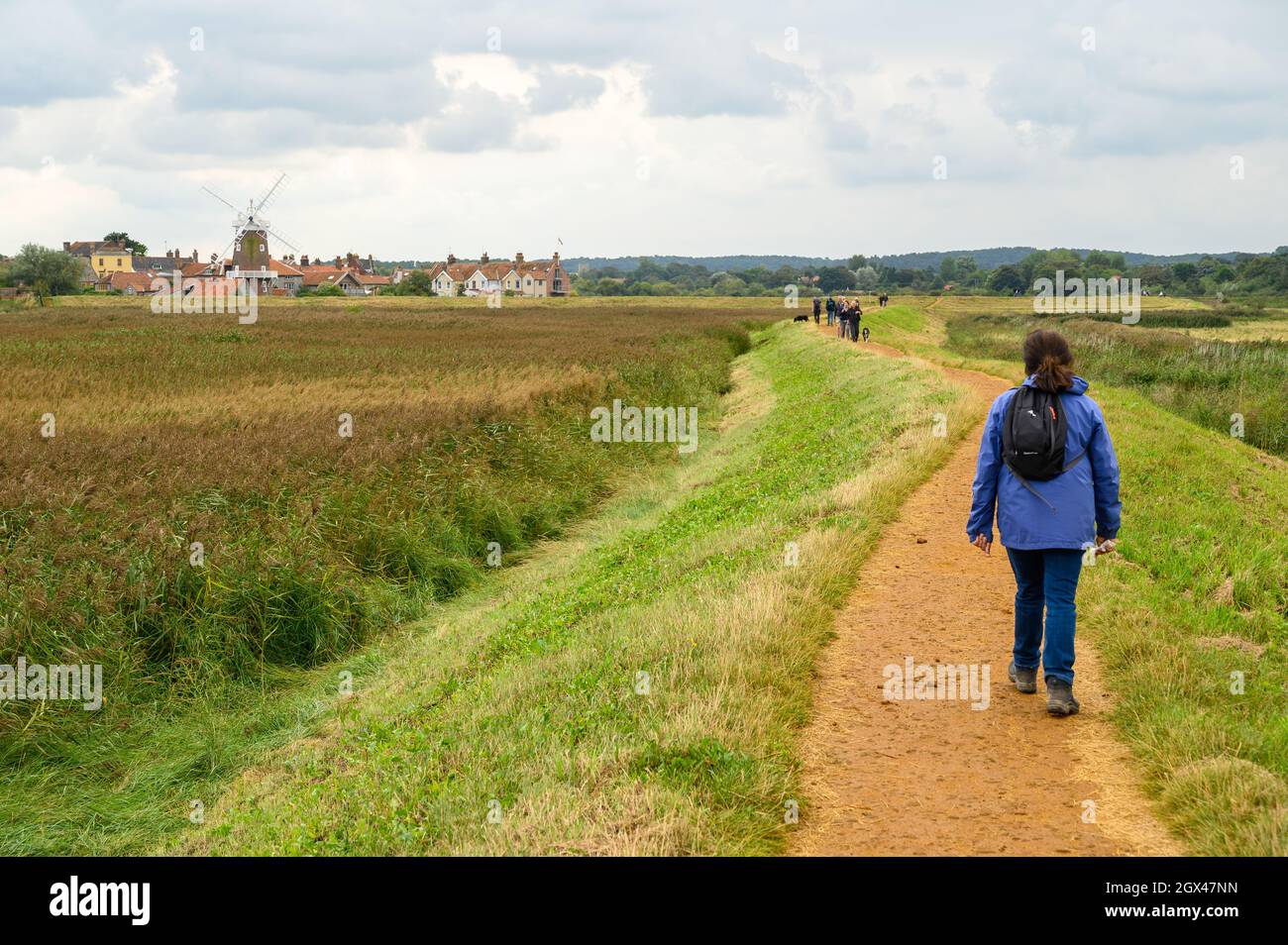 People walking on the Blakeney Freshes circular footpath with view to ...