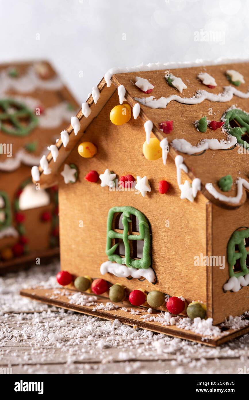 Christmas gingerbread house decorated with candies and glaze on wooden ...