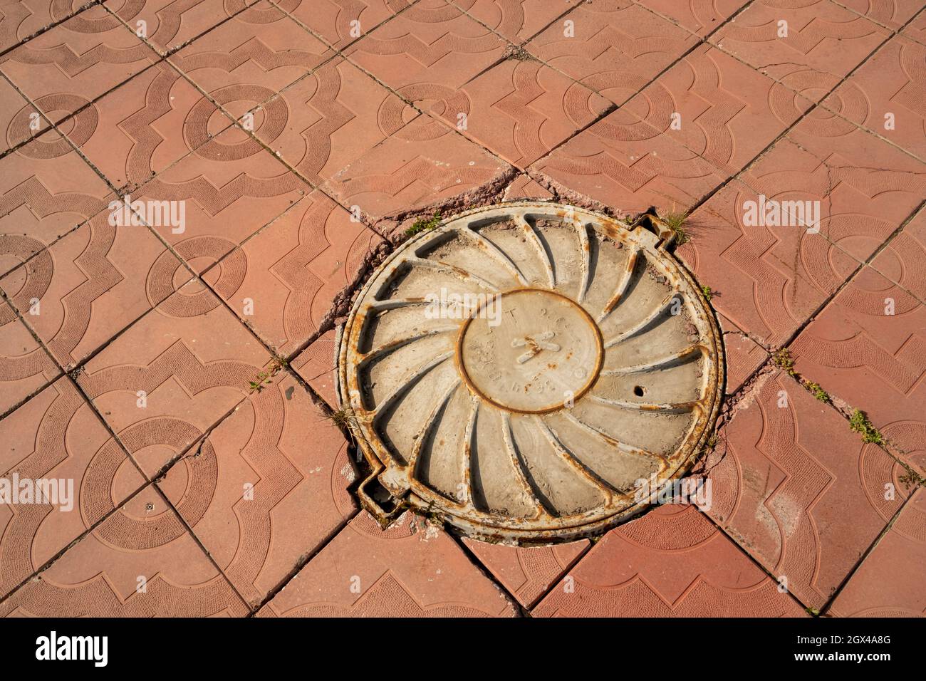 Embossed cast-iron cover of the manhole - part of the manhole cover is ...