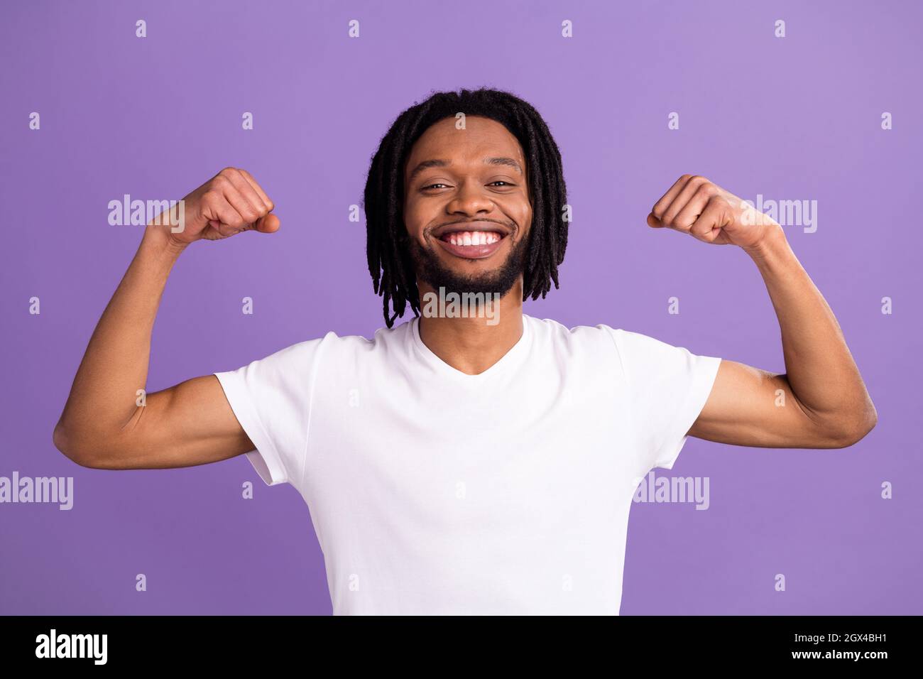 Portrait of attractive cheerful strong guy demonstrating powerful ...