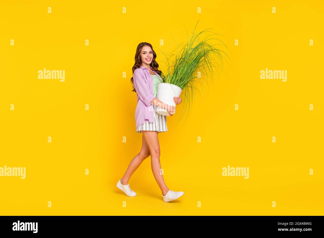 Full size photo of happy cheerful young woman walk empty space hold ...