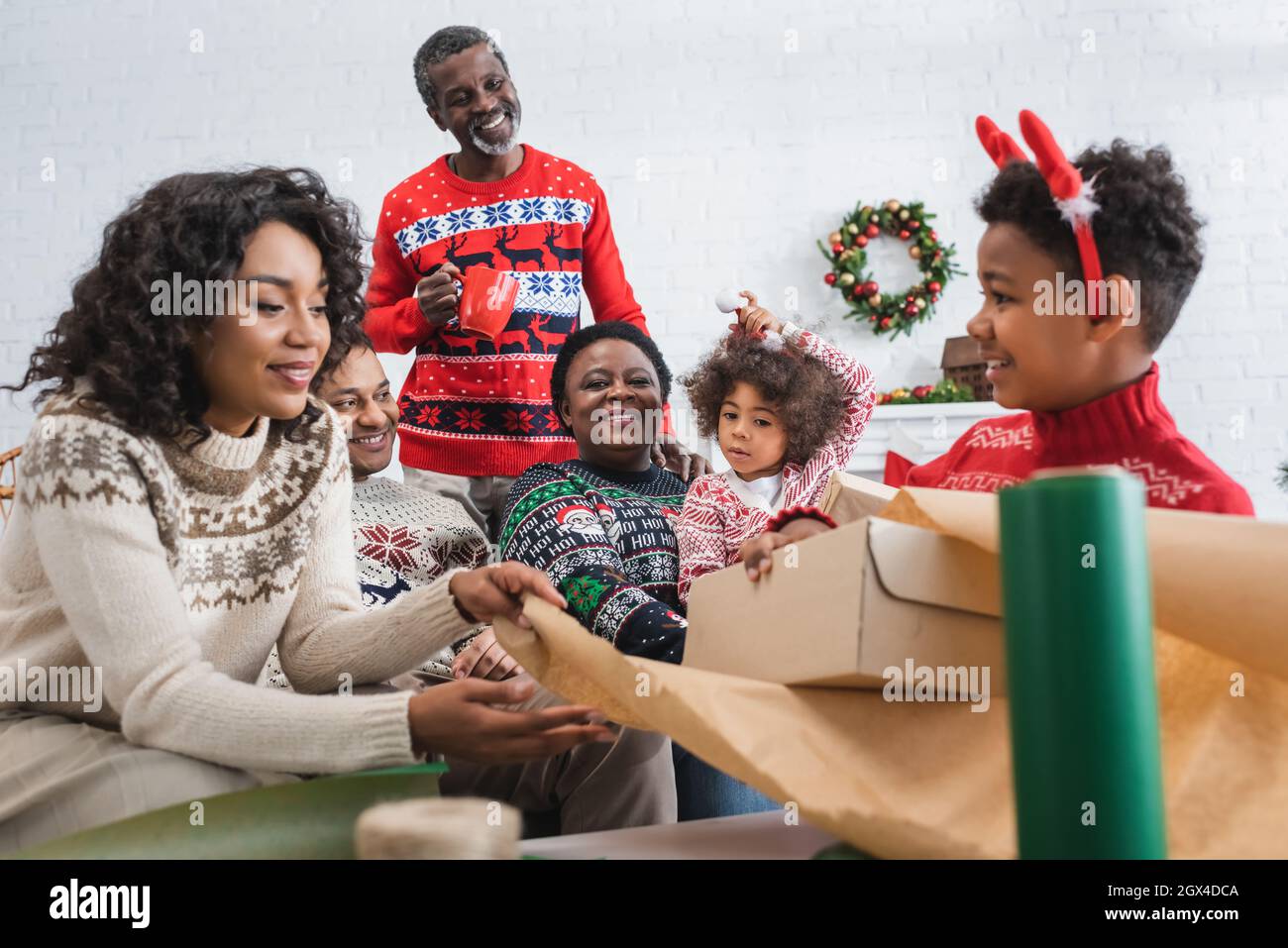 mother and son packing gift box near happy african american family ...