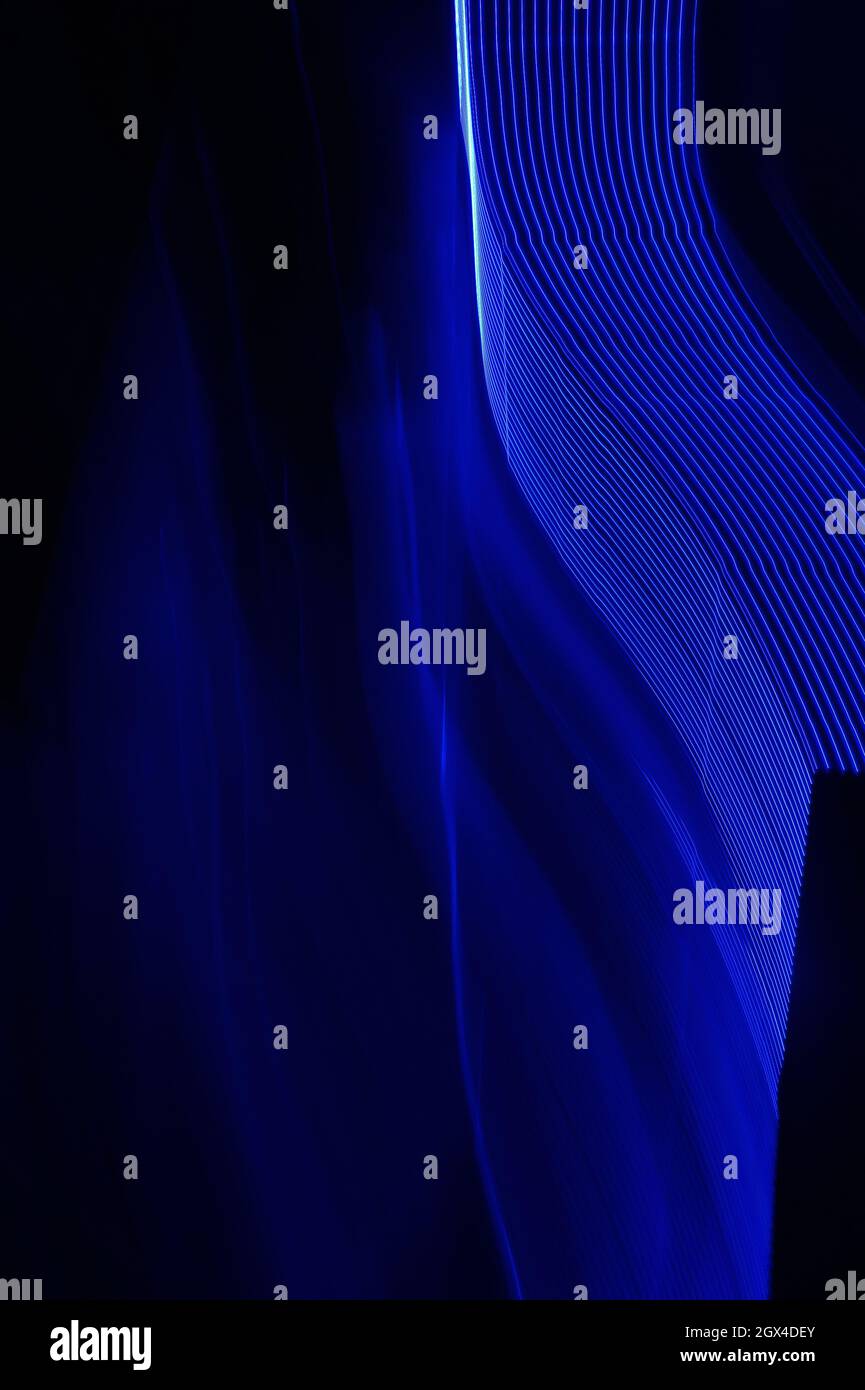 Neon blue light trails create a wavy pattern Stock Photo - Alamy