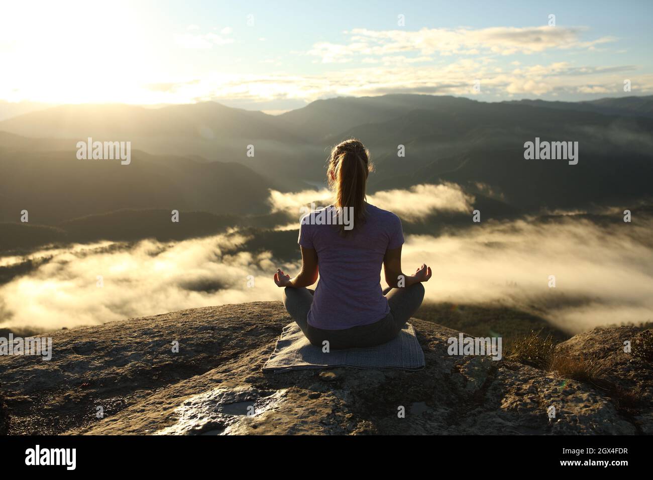 Back view of a yogi doing yoga in the mountain at sunrise Stock Photo ...