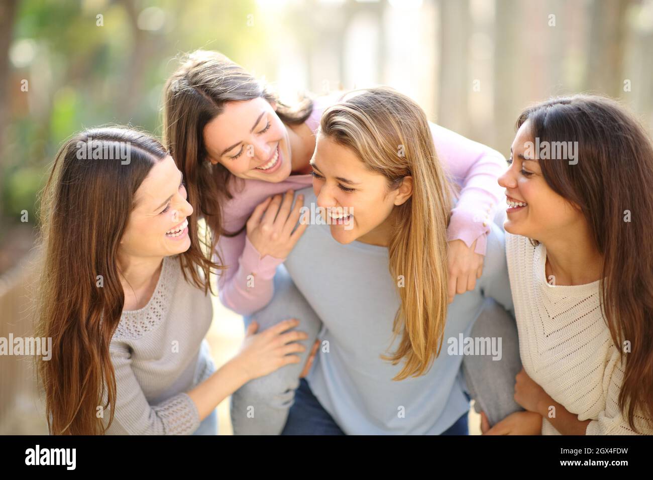 Four happy friends laughing and joking in the street Stock Photo - Alamy