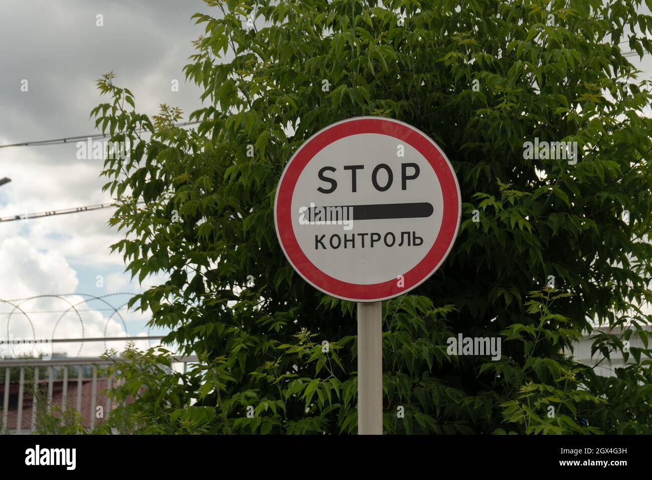 A road sign near the fence with barbed wire, prohibiting entry into the ...