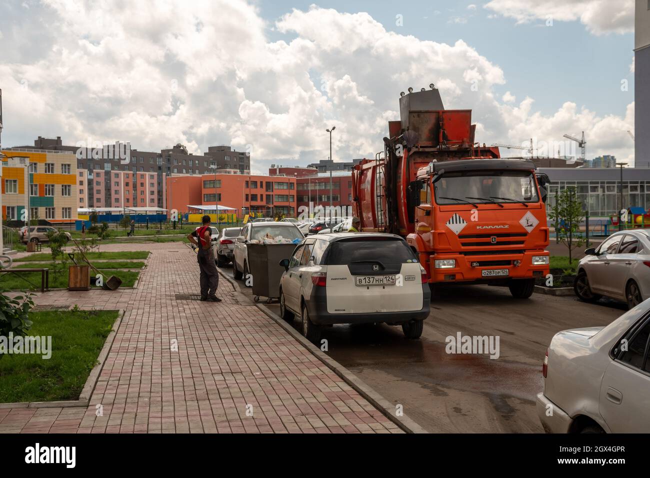 Recycling Company workers load garbage cans into a Garbage Truck ...
